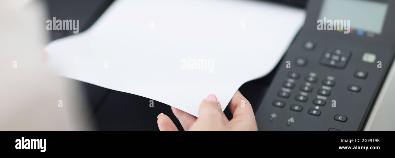 Person takes out white sheet from laser printer Stock Photo - Alamy