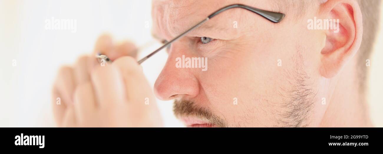 Portrait of concentrated male male taking off his glasses Stock Photo ...