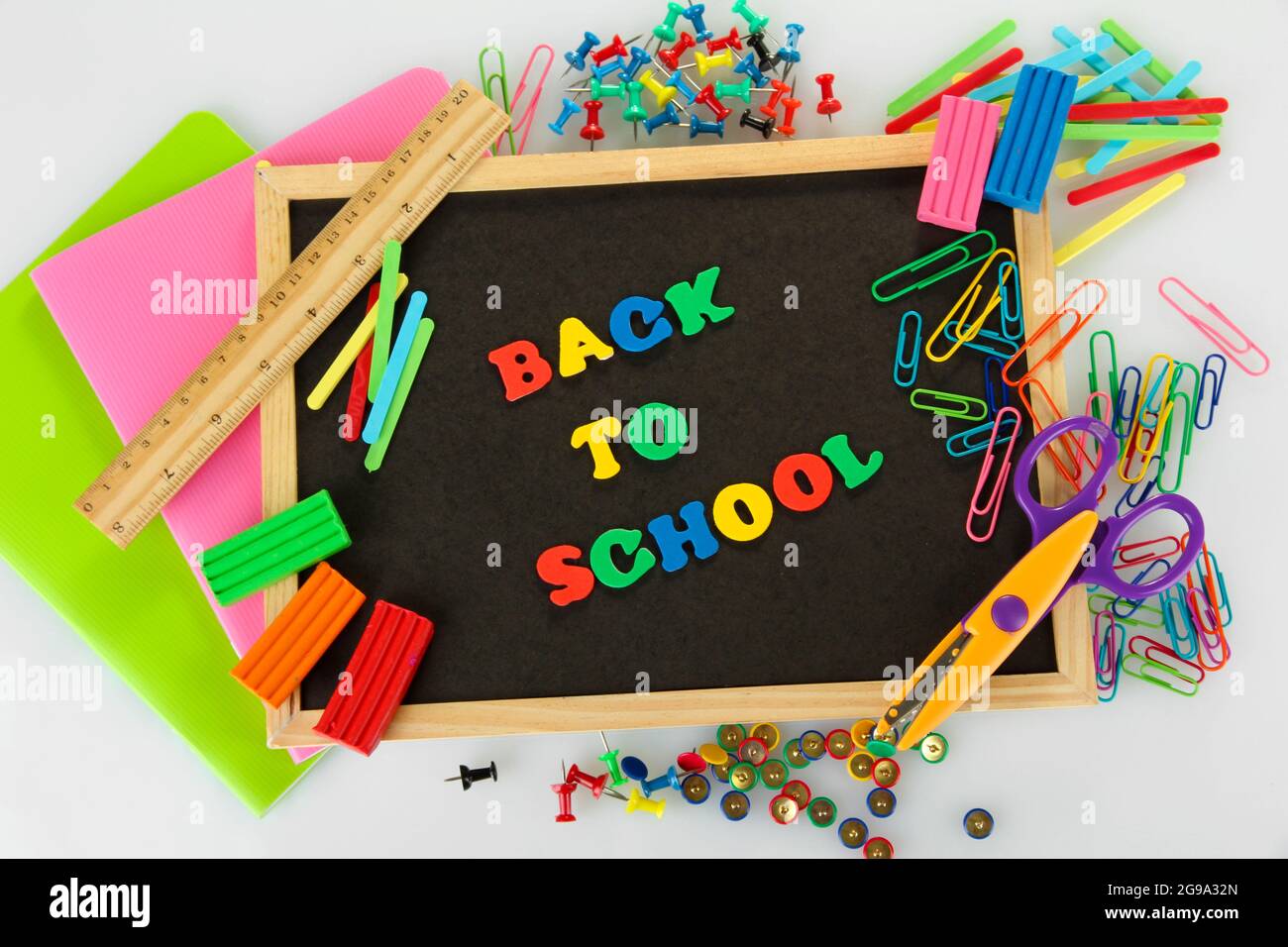 Small chalkboard with school supplies on white background. Back to ...