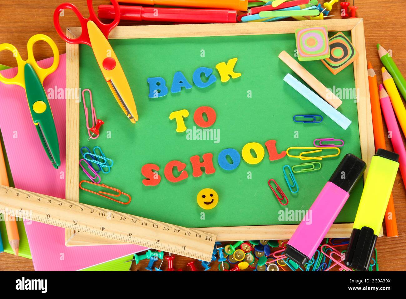 Small chalkboard with school supplies on wooden background. Back to ...