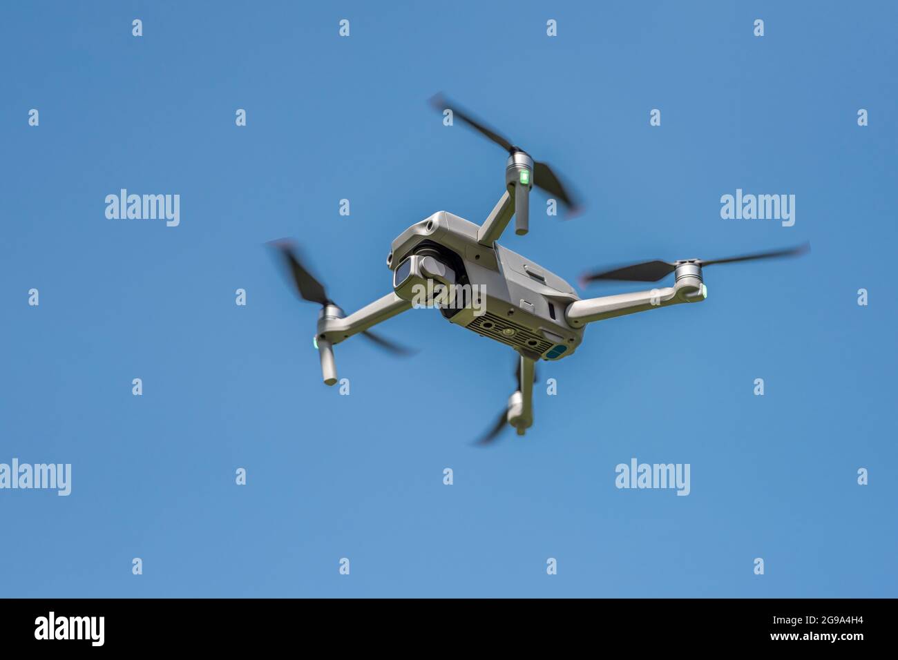 Flying drone with camera on a blue background with copy space. Airborne ...