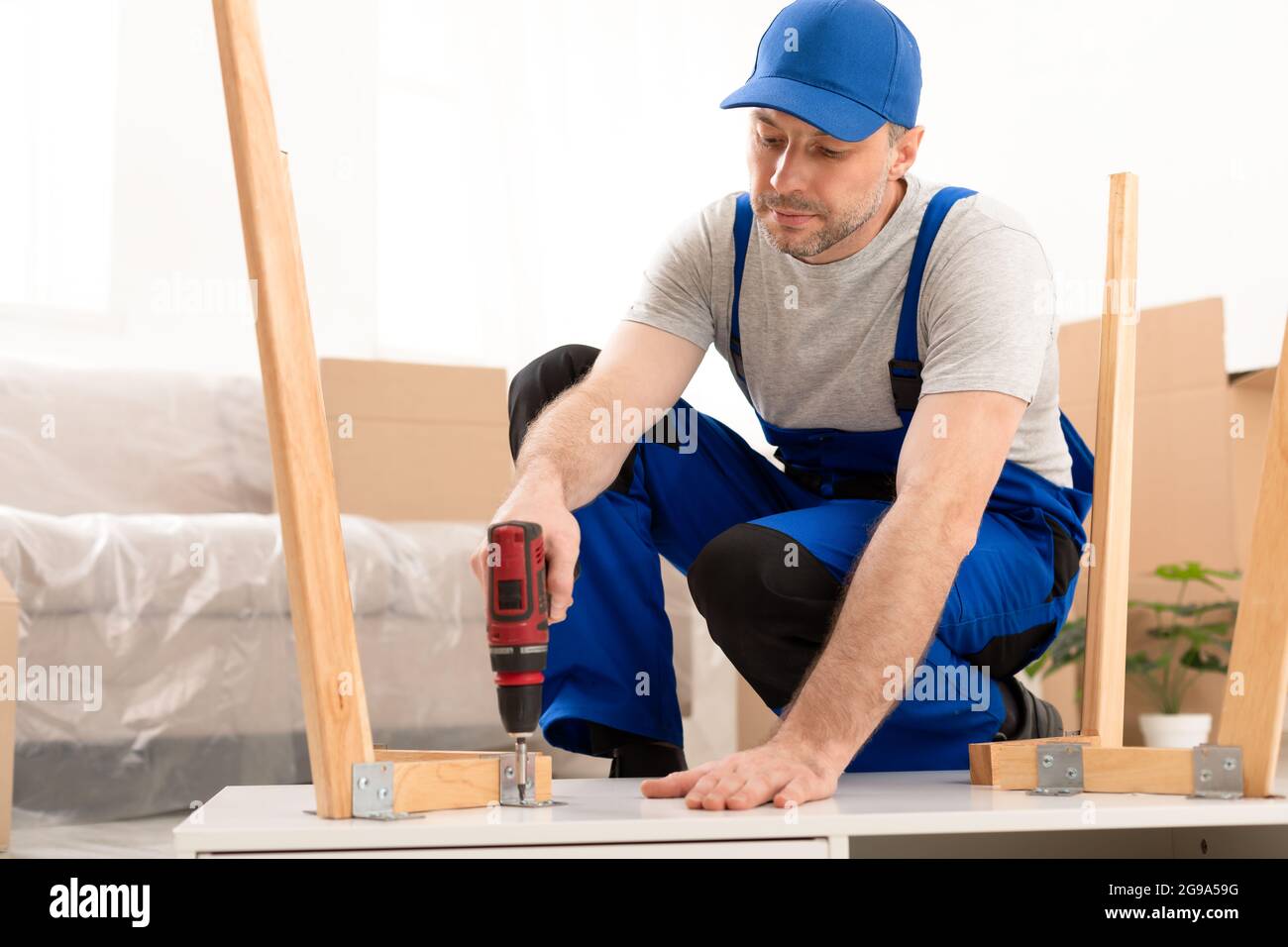 Handyman Assembling Wooden Table With Electric Drill Indoor Stock Photo ...