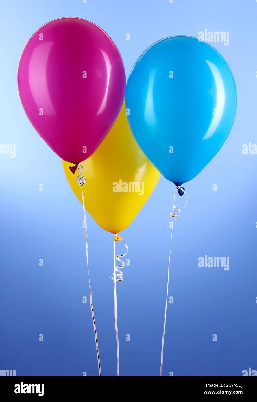 Three colorful balloons on blue background Stock Photo - Alamy