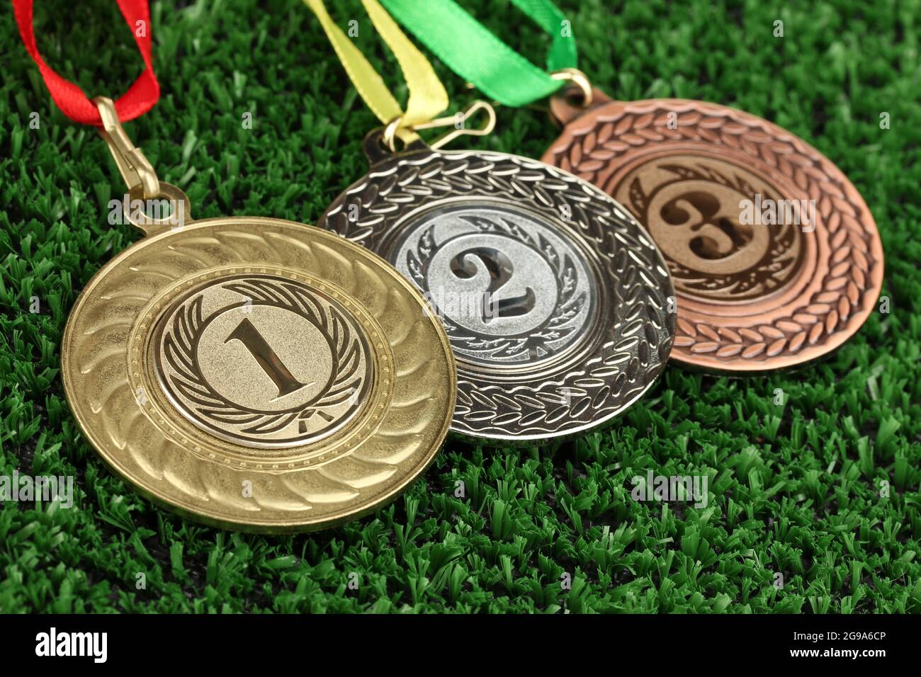 Three medals on grass background Stock Photo - Alamy
