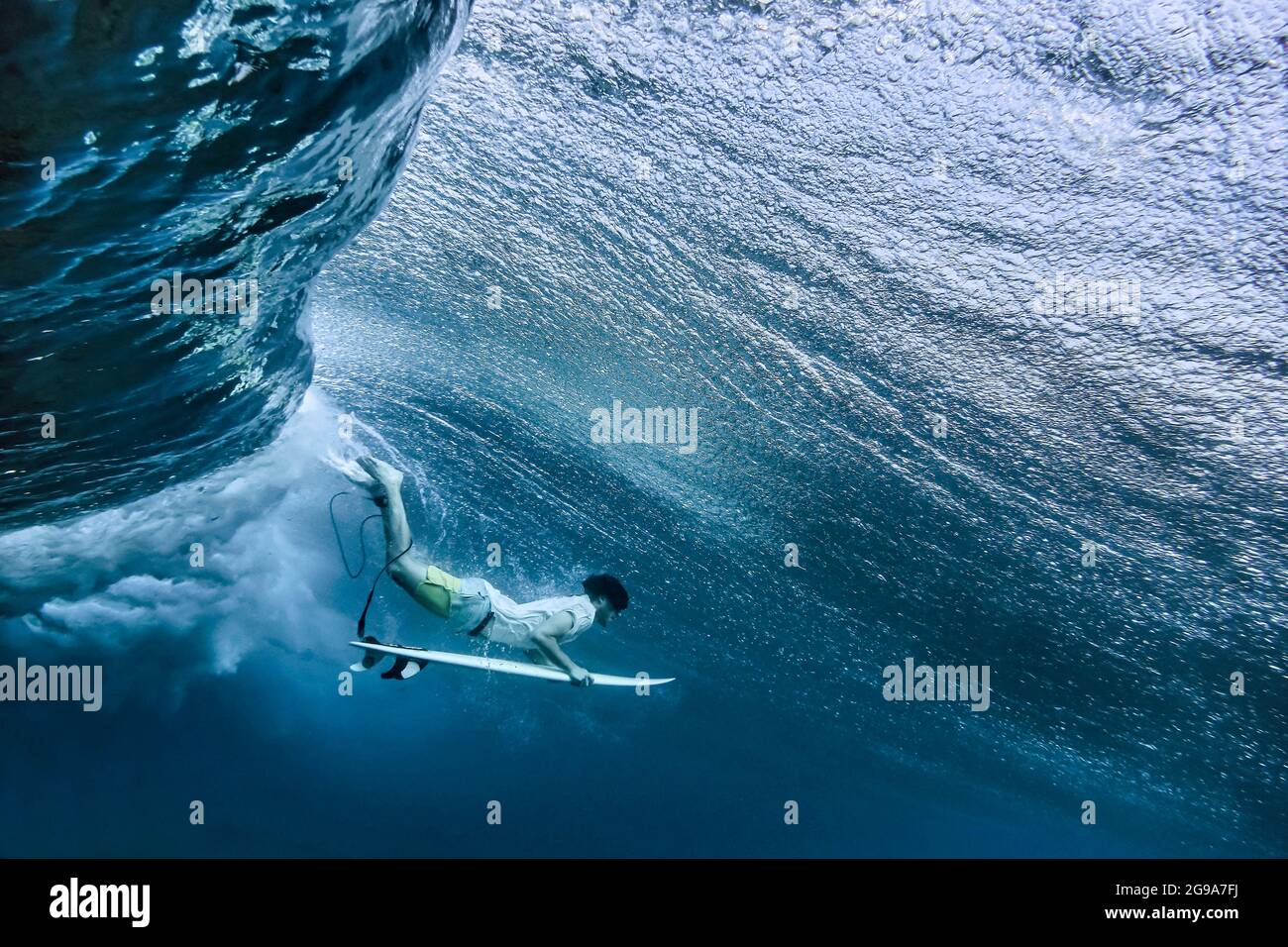 Male surfer holding surfboard while diving undersea at Maldives Stock ...