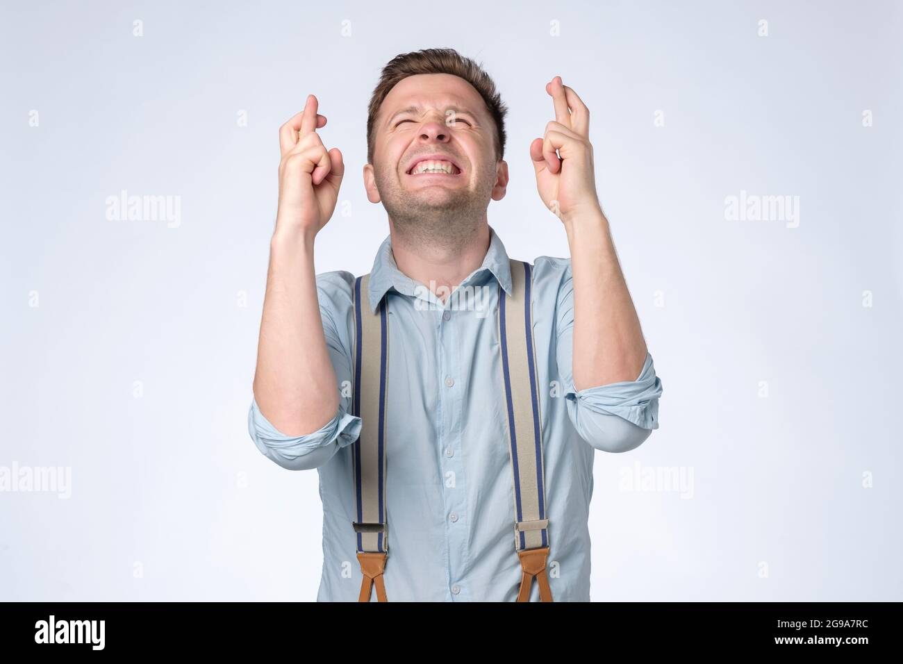 Young man making a wish isolated on white background Stock Photo - Alamy