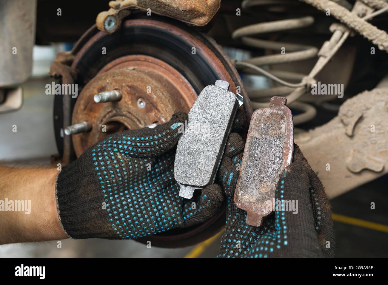 The car mechanic shows for comparison a worn brake shoe and a new one ...