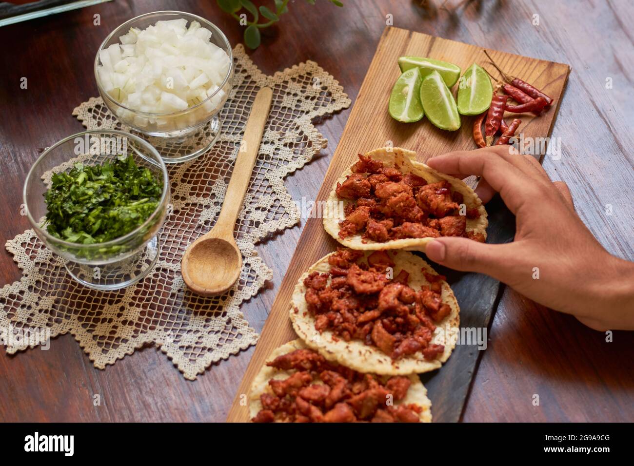 Authentic Mexican tacos on wooden table. Hand grabbing taco. Mexican ...