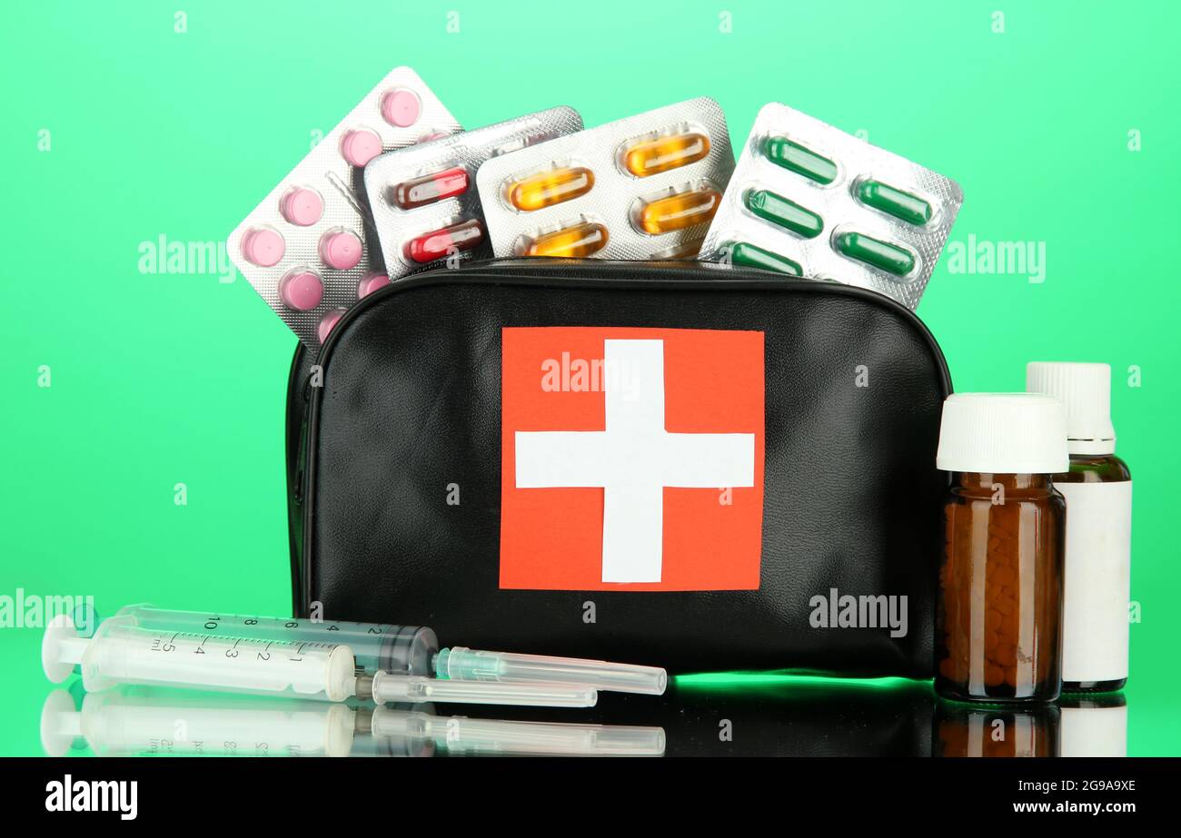 First aid bag, on green background Stock Photo - Alamy