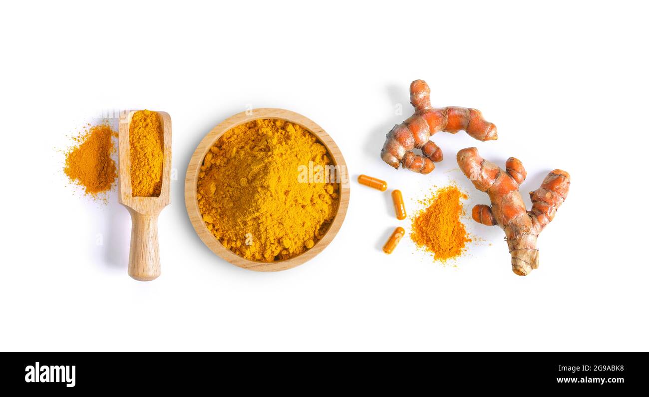 Turmeric (Curcuma) powder pile in wood bowl and capsule isolated on ...