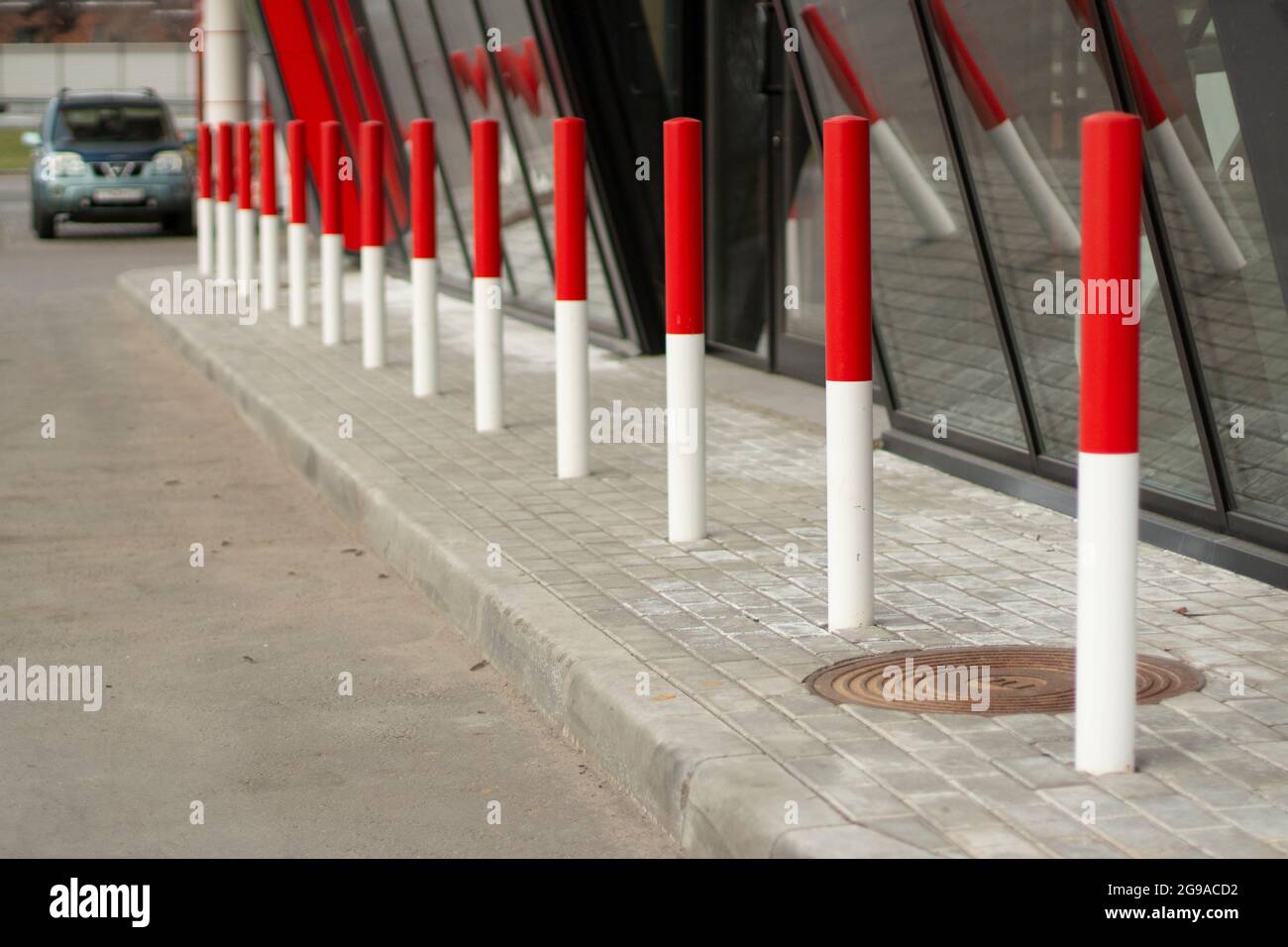 Red posts in the parking lot. Car traffic limiters. Red-white pillars ...