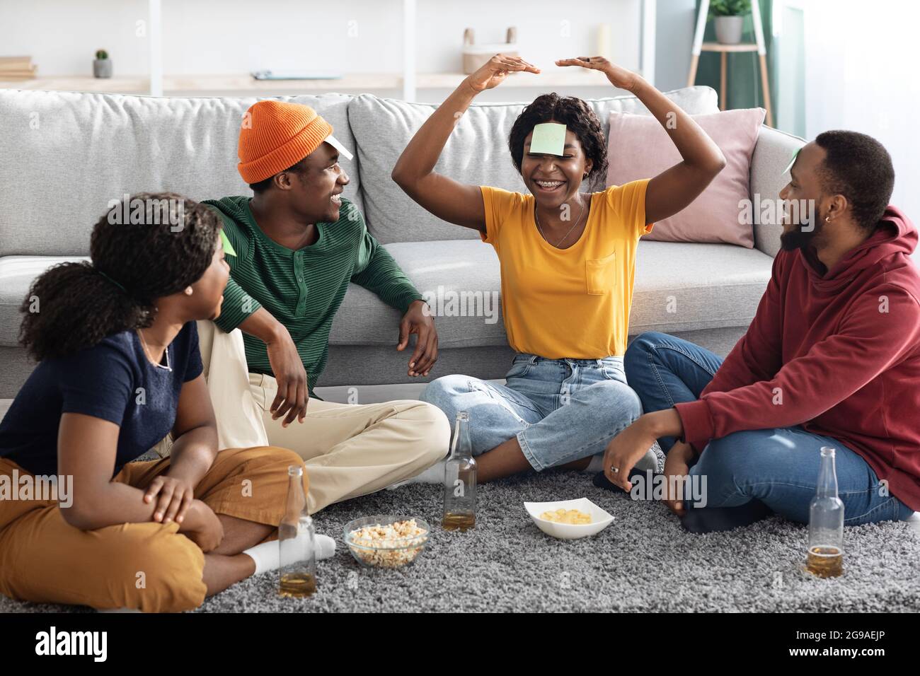 Funny black friends playing guess who at home Stock Photo - Alamy