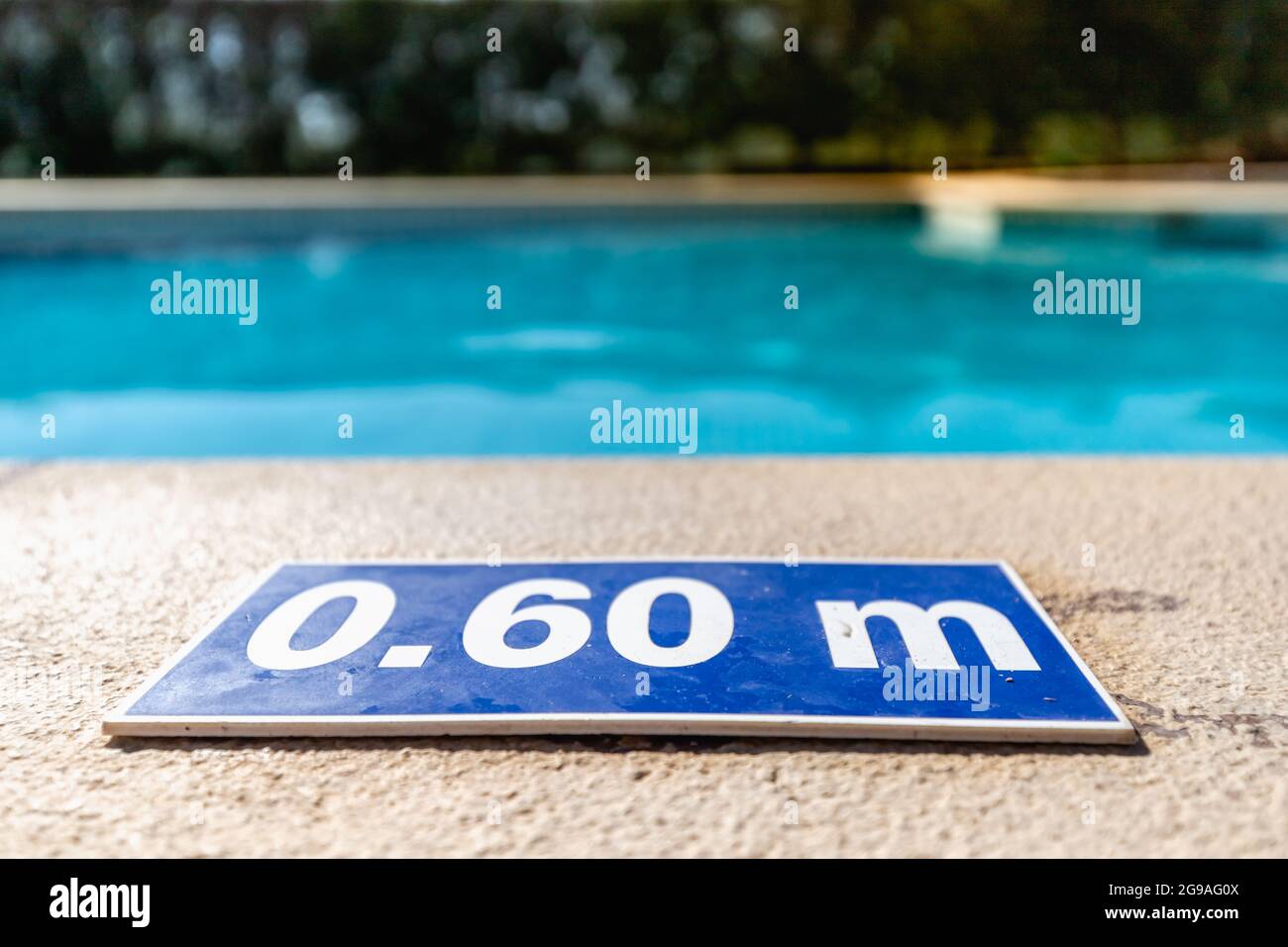 blue plastic plate at the edge of a swimming pool indicating a depth of ...