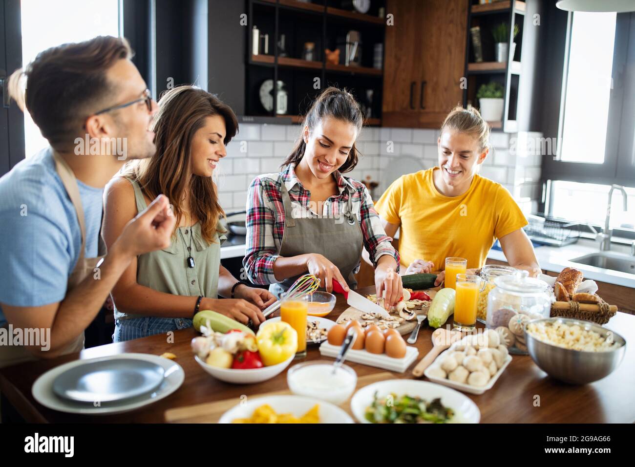Young group of friends preparing vegetable meal and making fun Stock ...