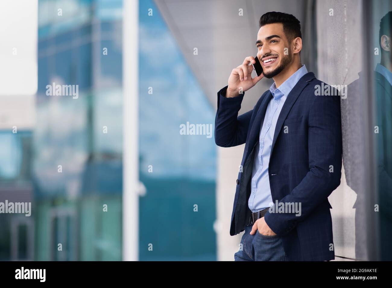 Rich young businessman having phone conversation next to office ...