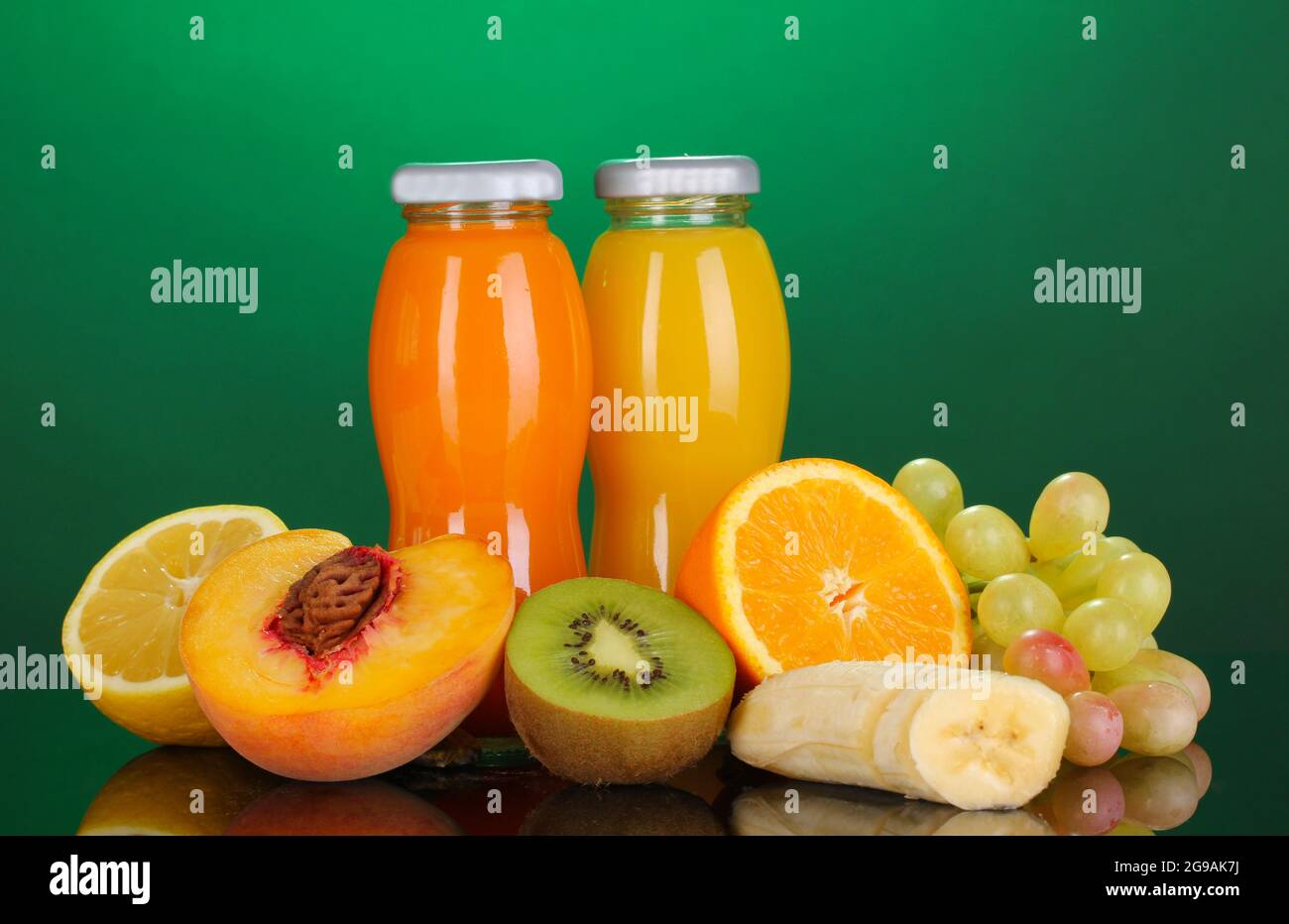 Delicious multifruit juice in a bottle and fruit next to it on green ...