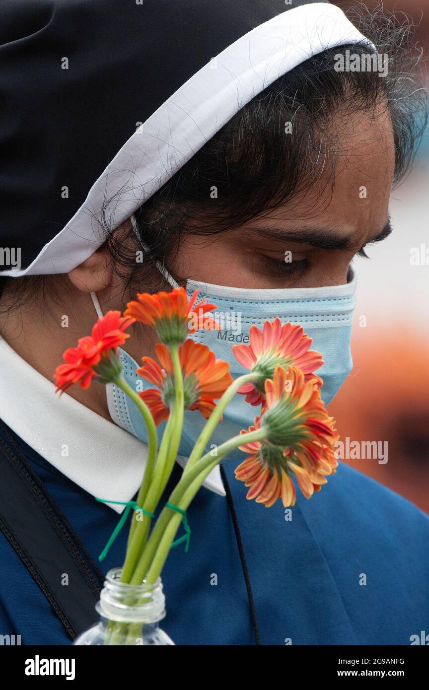 July 25, 2021. : Nun and Faithful hold a gerbera flower symbolic of ...