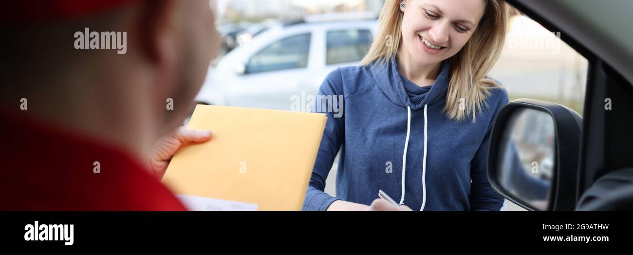 Woman signing documents and receiving yellow postal envelope Stock ...