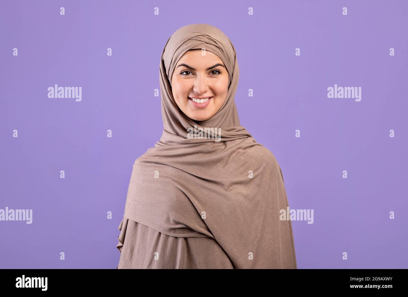 Portrait of beautiful armenian muslim woman in hijab over purple ...