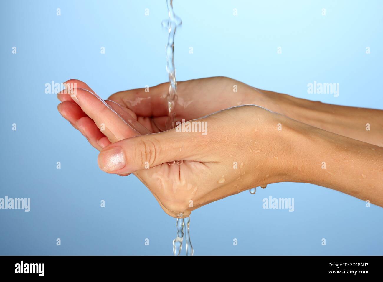 Washing hands on blue background close-up Stock Photo - Alamy