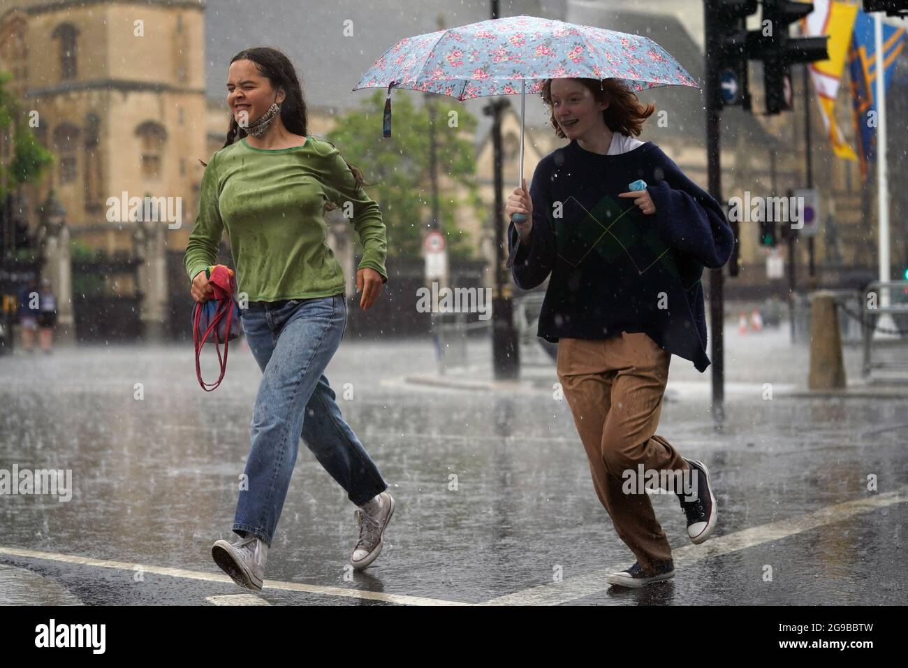 Women run through heavy rain hi-res stock photography and images - Alamy