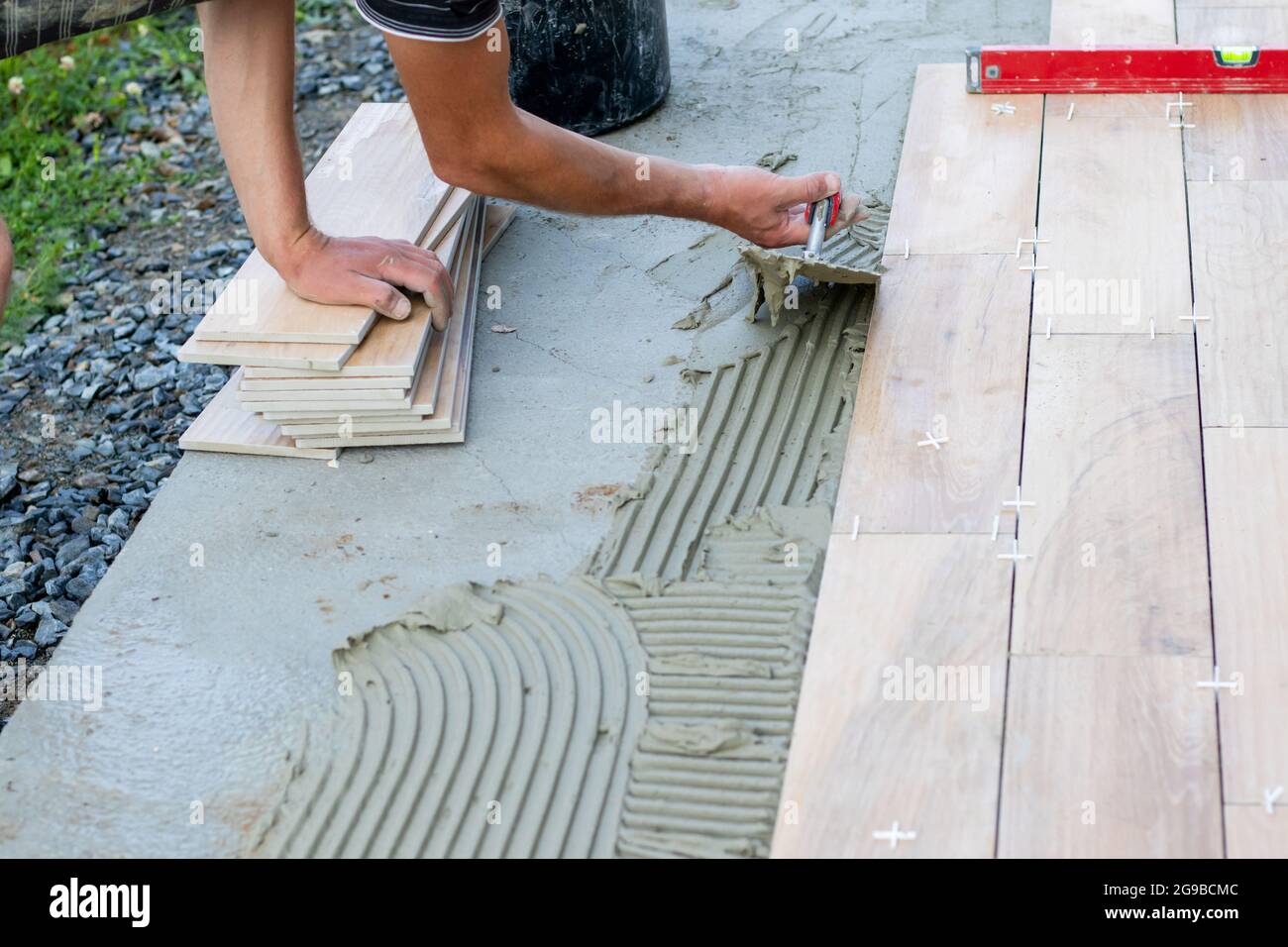 The hands of the professional tiler lying or installing modern, ceramic ...