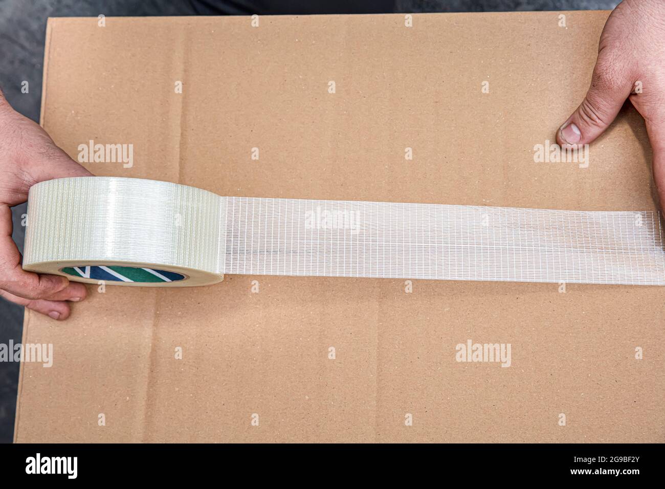Packing Boxes with Tape. Sticking duct tape to a Kraft cardboard box ...