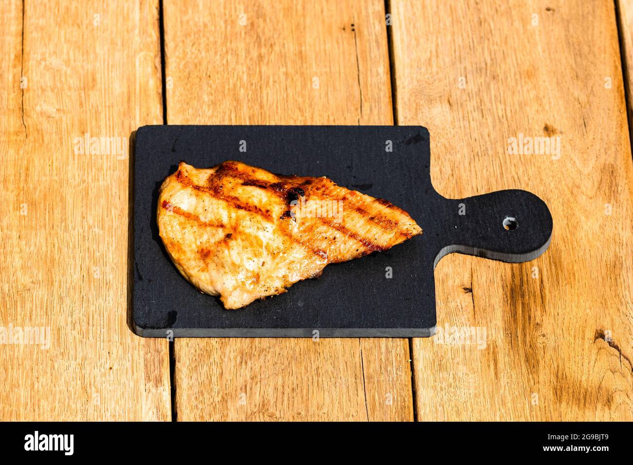 An overhead shot of grilled steak on small black chopping board Stock ...