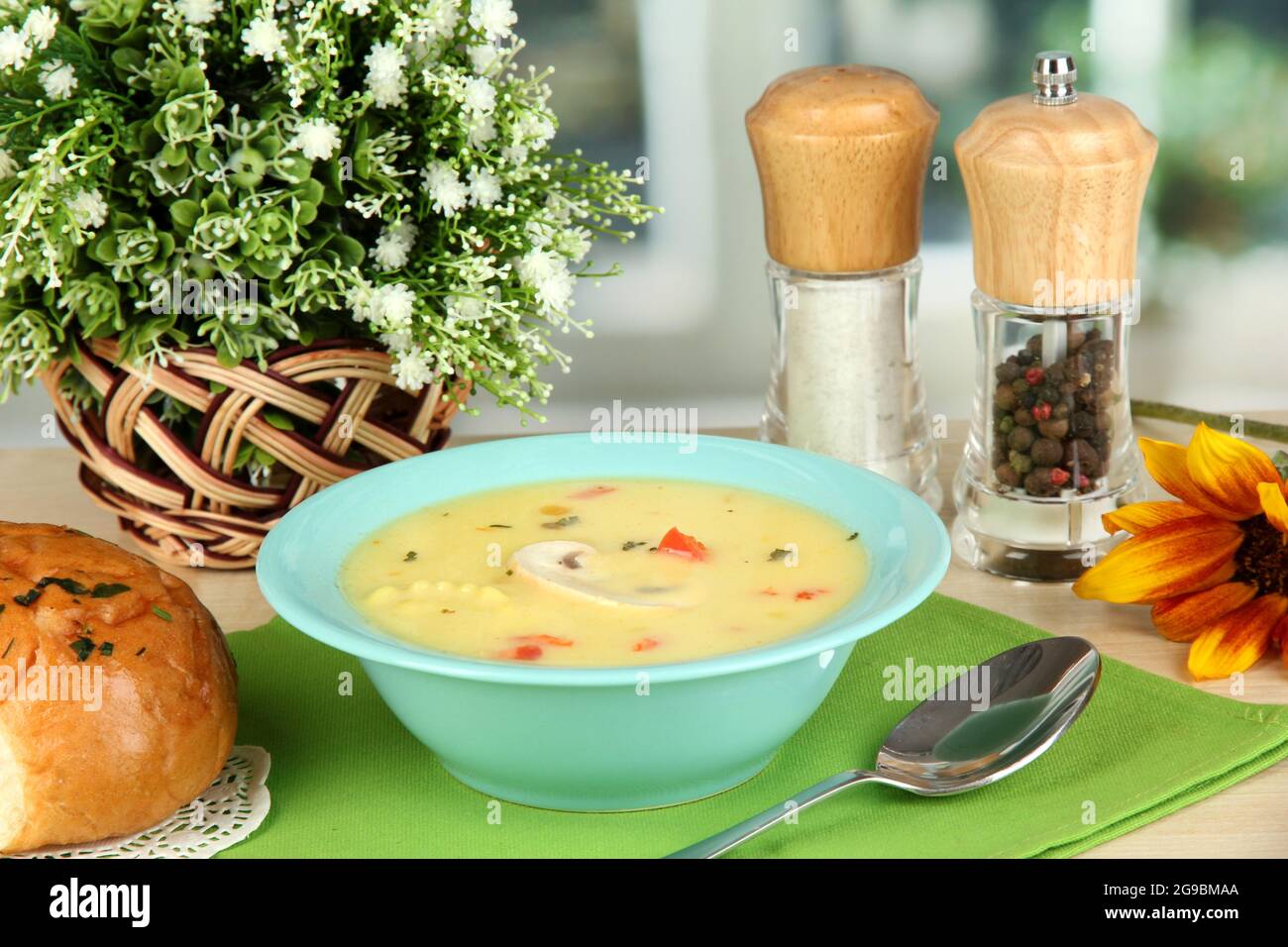 Fragrant soup in blue plate on table on window background close-up ...