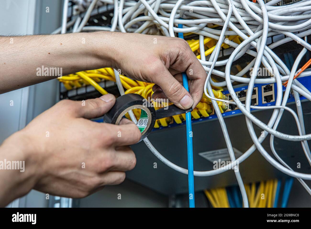 Electrician is repairing the wiring in the electrical room with ...