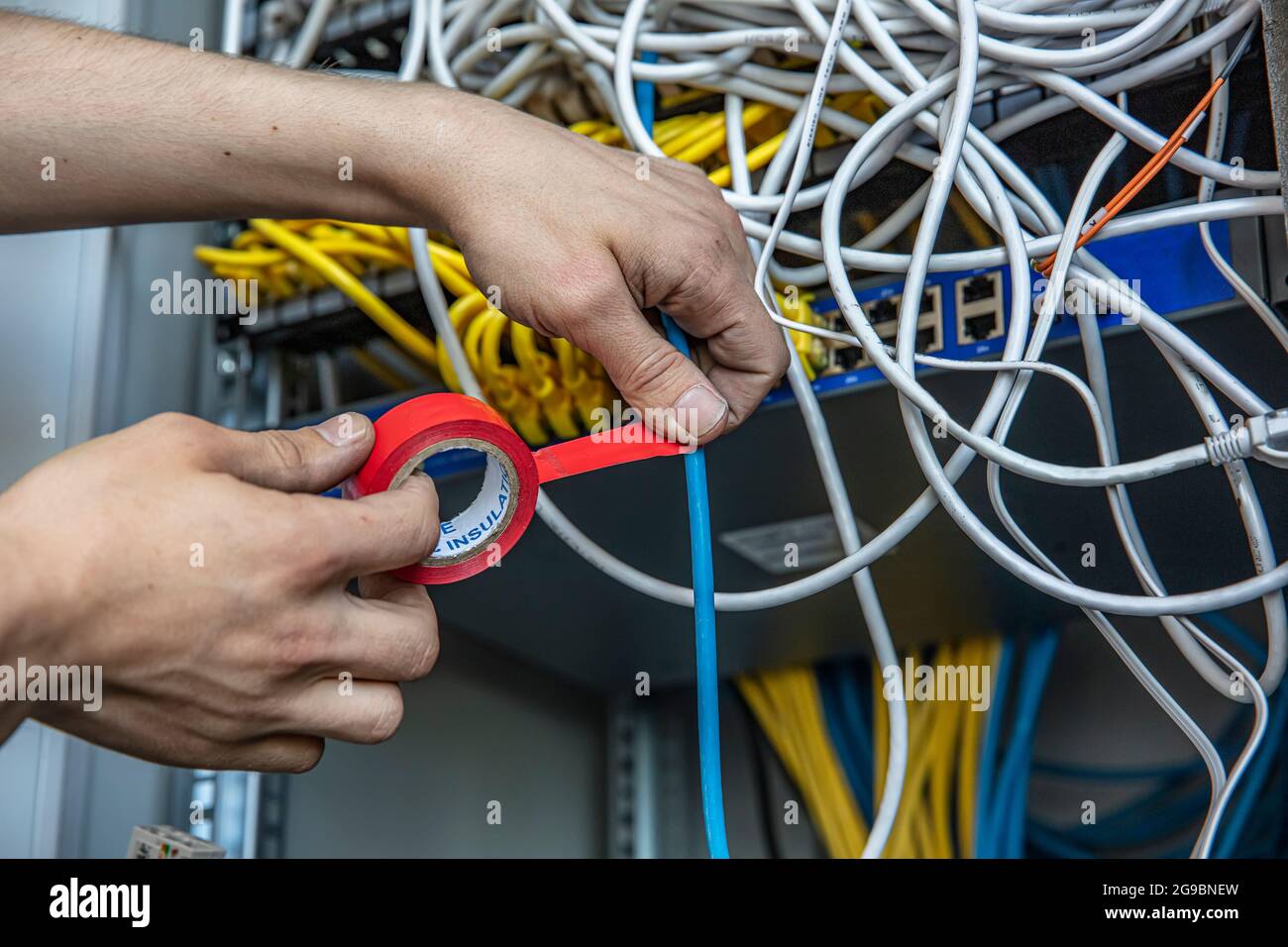 Electrician is repairing the wiring in the electrical room with ...