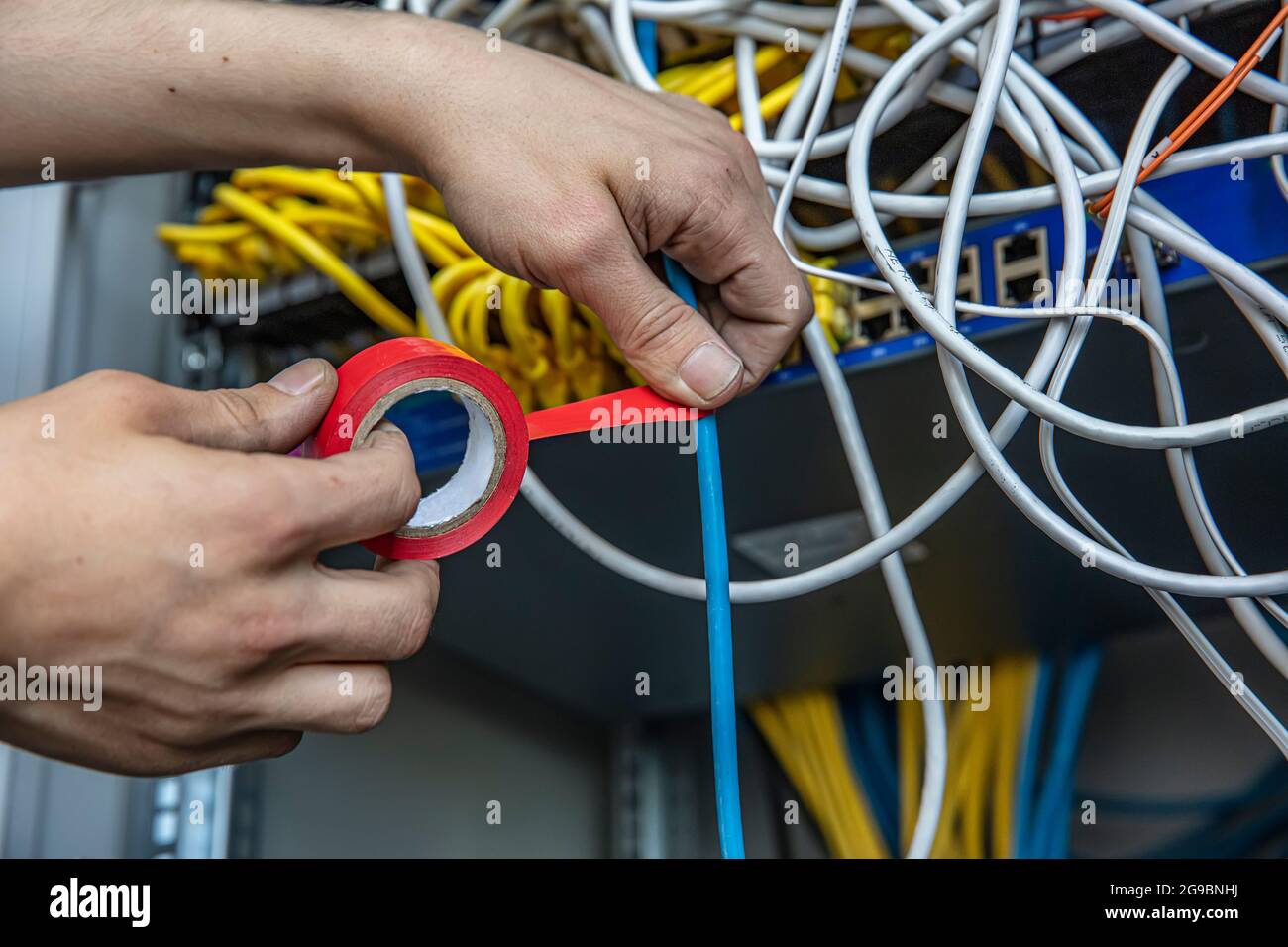 Electrician is repairing the wiring in the electrical room with ...