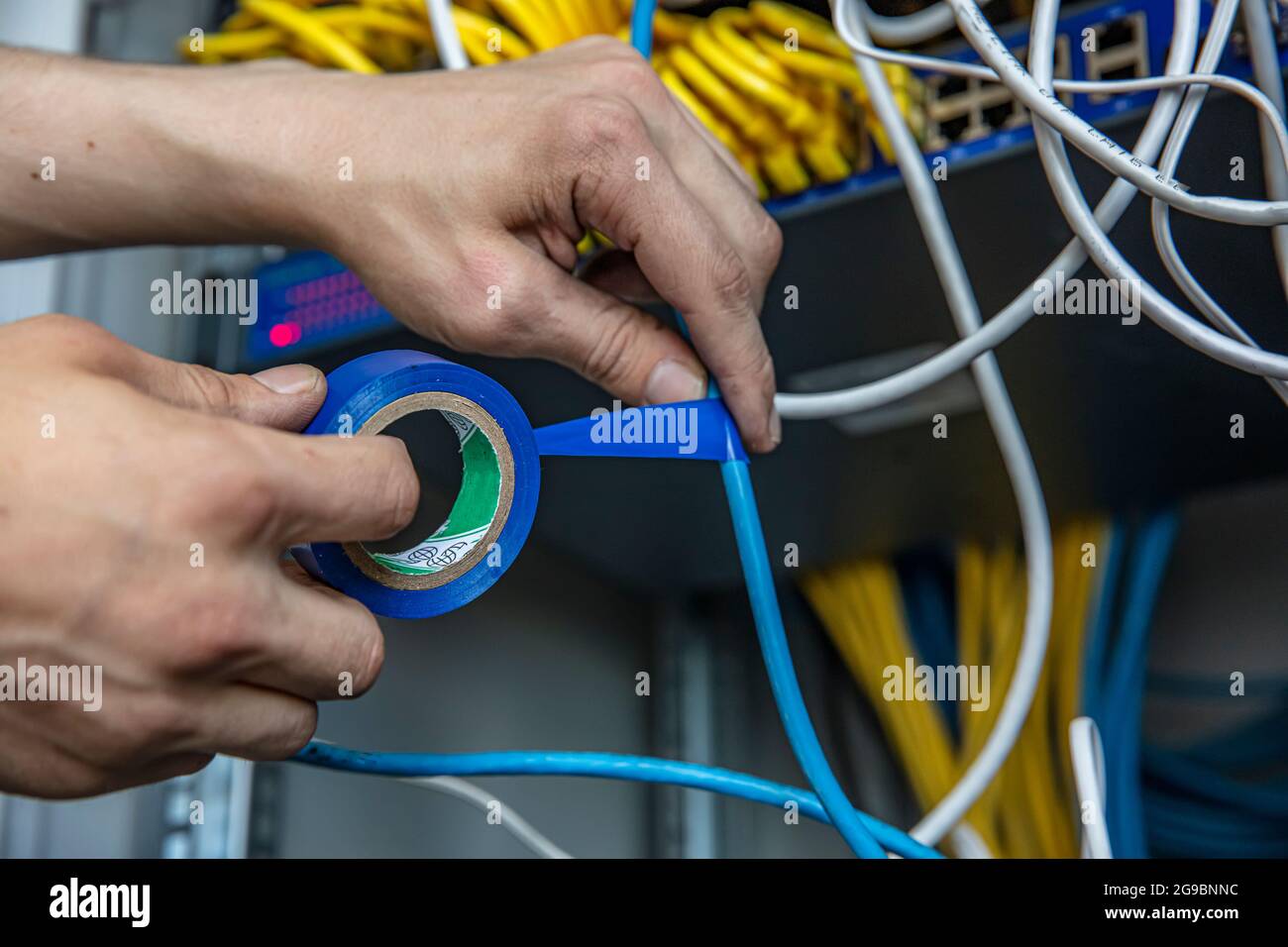 Electrician is repairing the wiring in the electrical room with ...