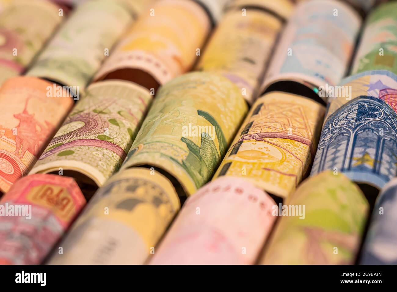 Different colourful banknotes from various countries on rolls to be ...