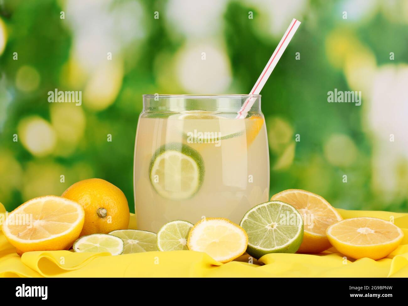 Citrus lemonade in glass bank of citrus around on yellow fabric on ...