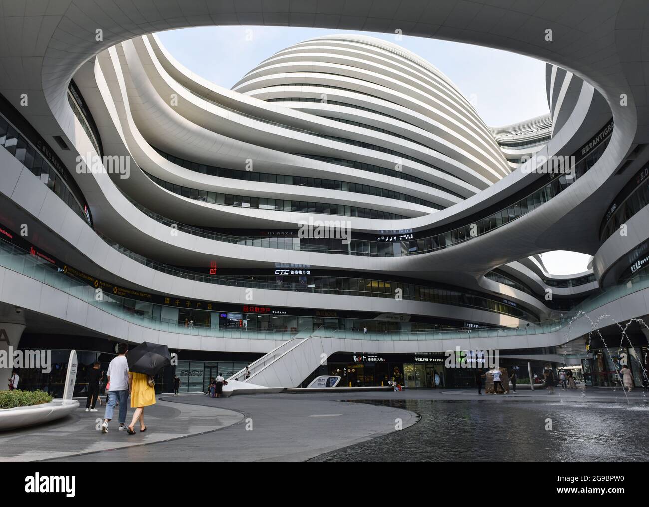 Beijing, China. 25th July, 2021. People walk near the galaxy SOHO ...