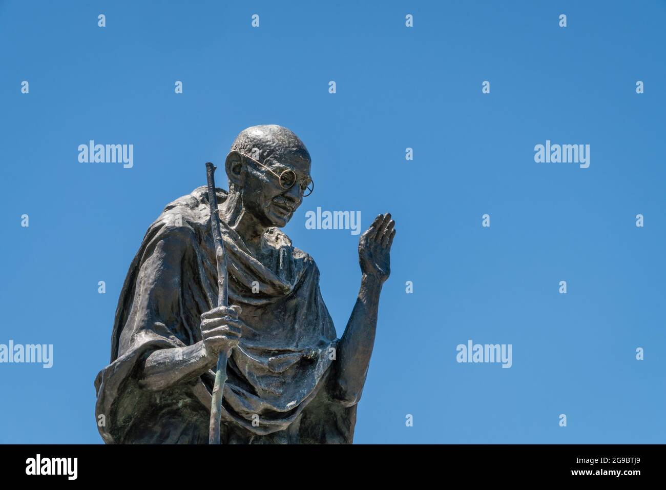 Statue of Mahatma Gandhi against bright blue background Stock Photo - Alamy
