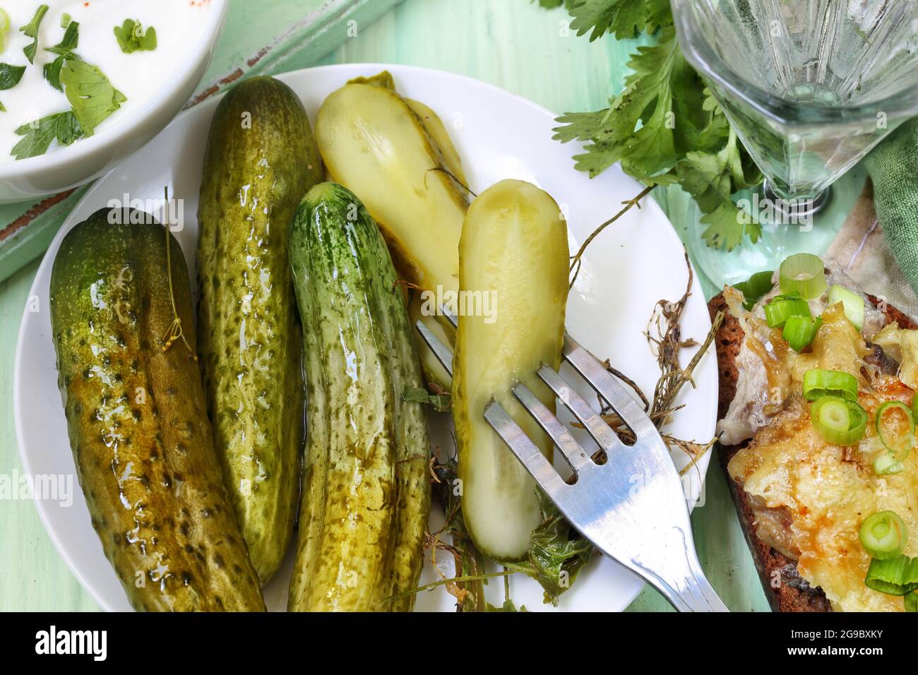 Lightly salted cucumbers on a green background Stock Photo - Alamy