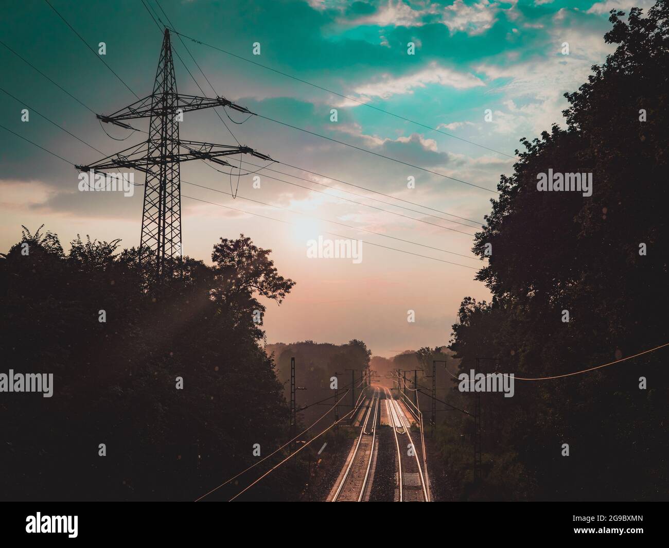 A stunning view of two parallel railroads through lush trees under a ...