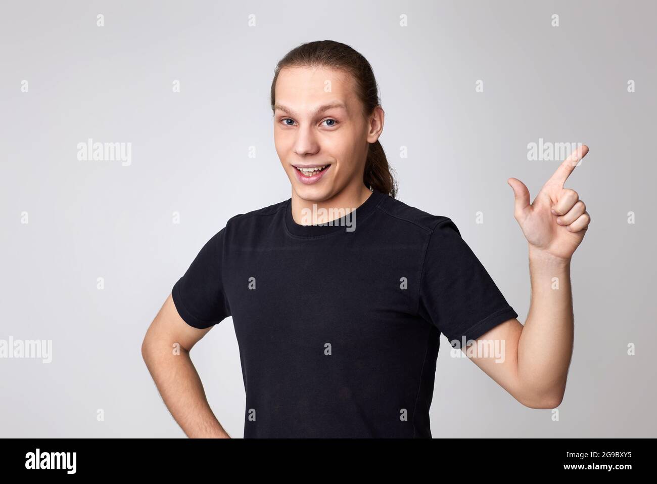 Positive young man pointing up at empty space Stock Photo - Alamy