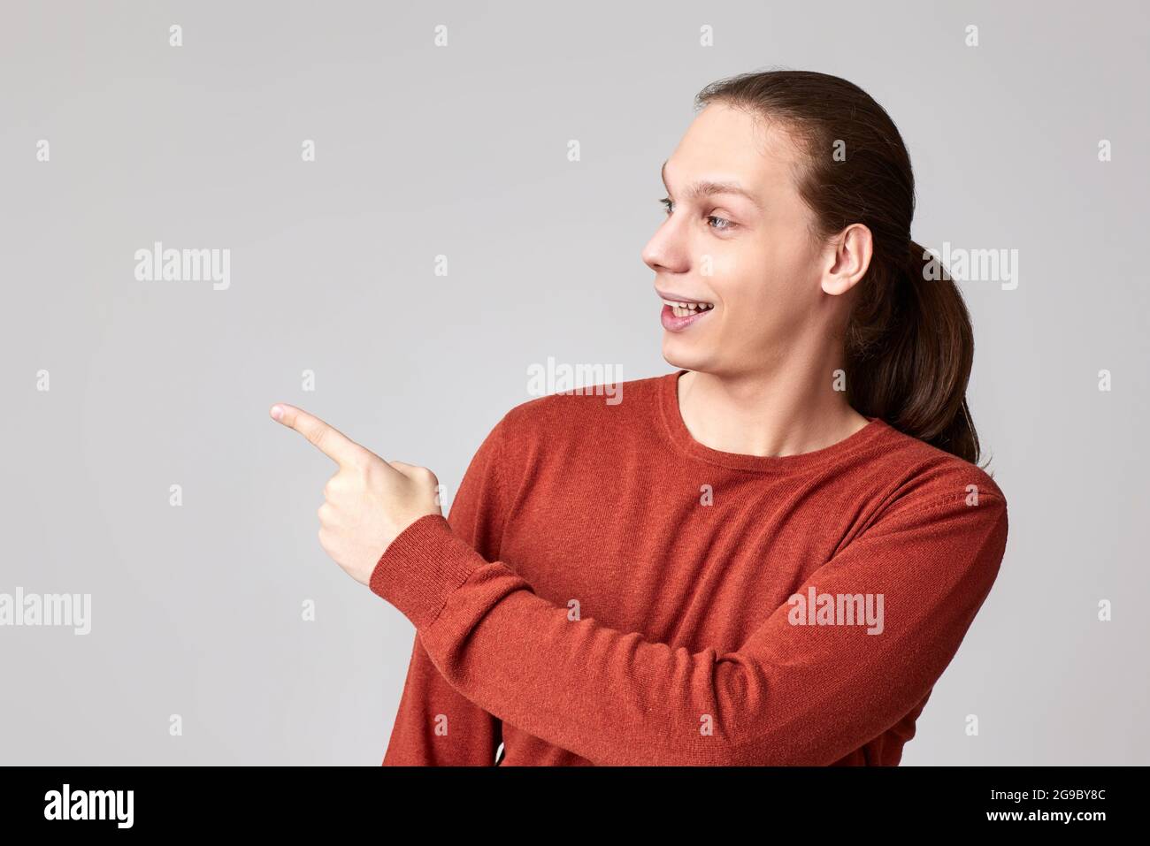 young man pointing finger away at empty space Stock Photo - Alamy
