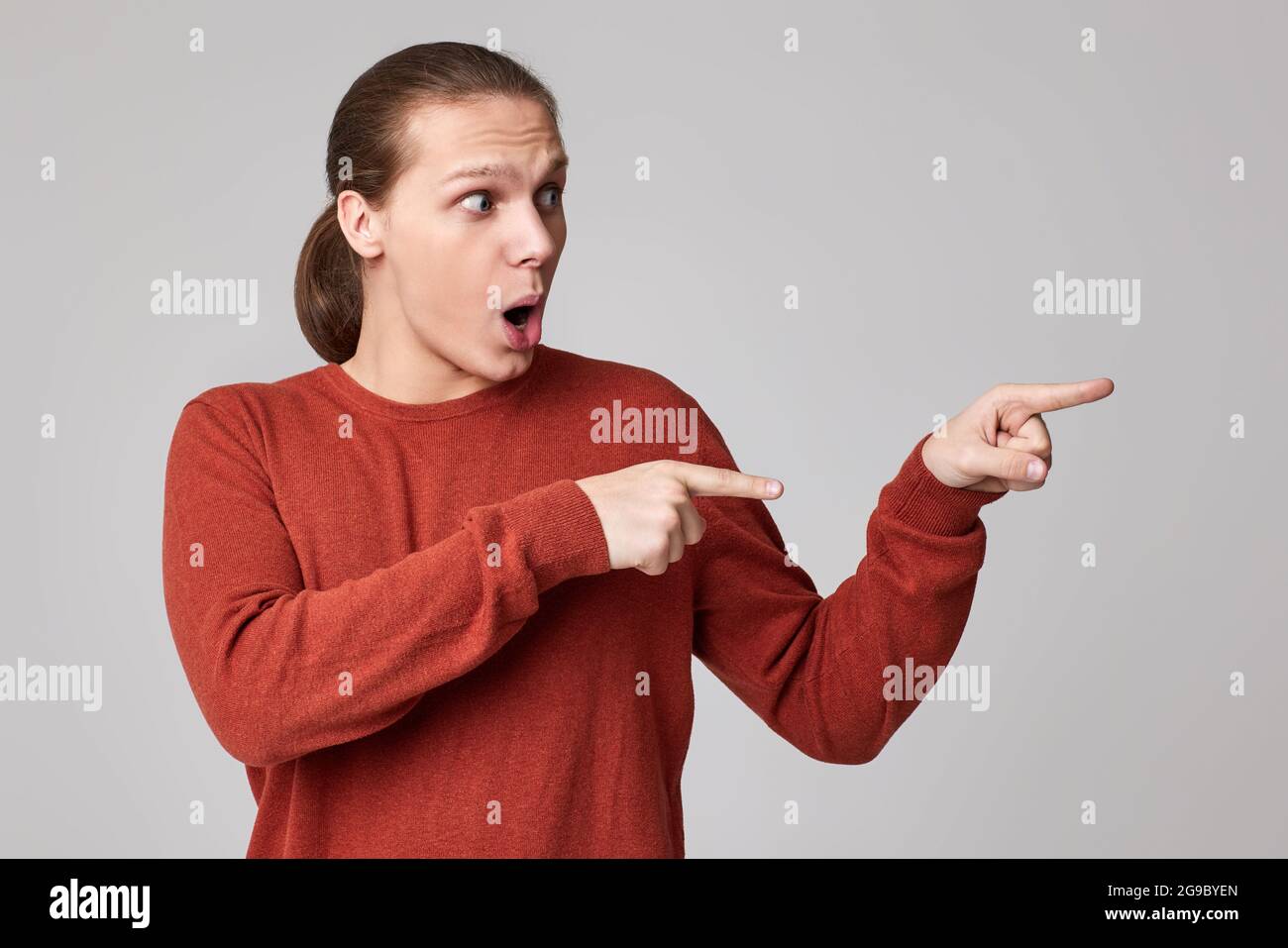 young man pointing finger away at empty space Stock Photo - Alamy