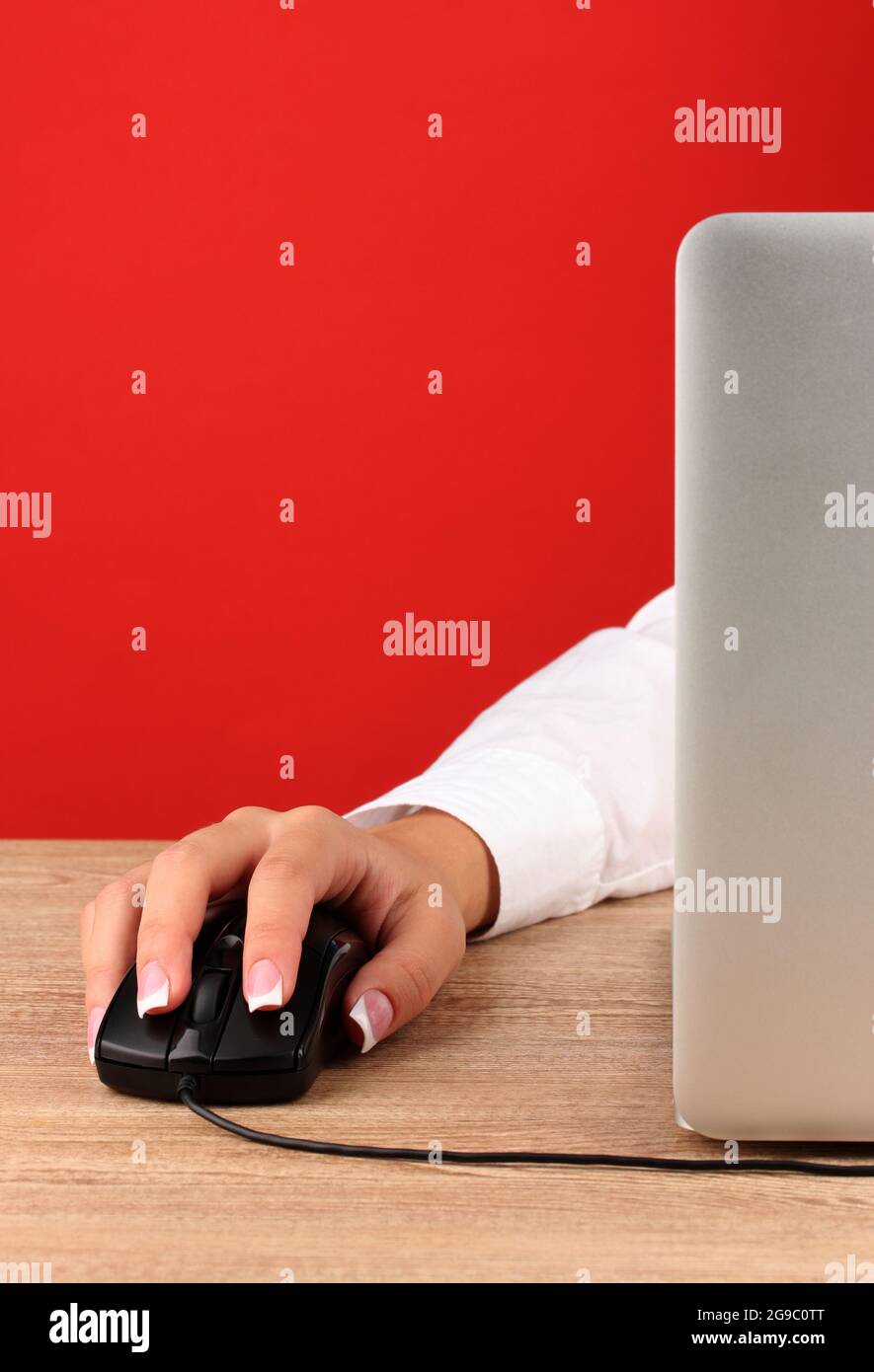 woman's hands pushing keys of pc mouse, on red background close-up ...