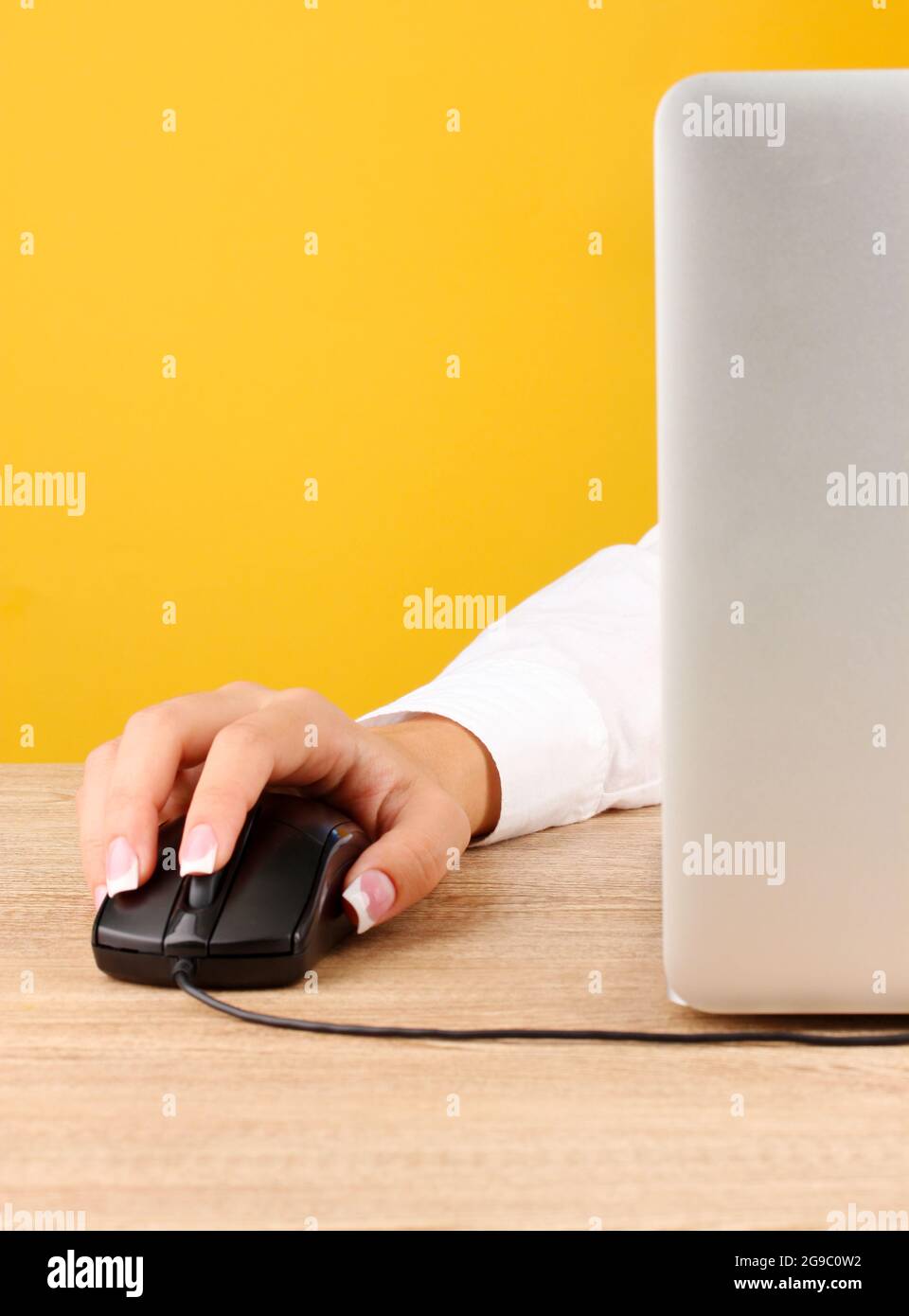 woman's hands pushing keys of pc mouse, on yellow background close-up ...