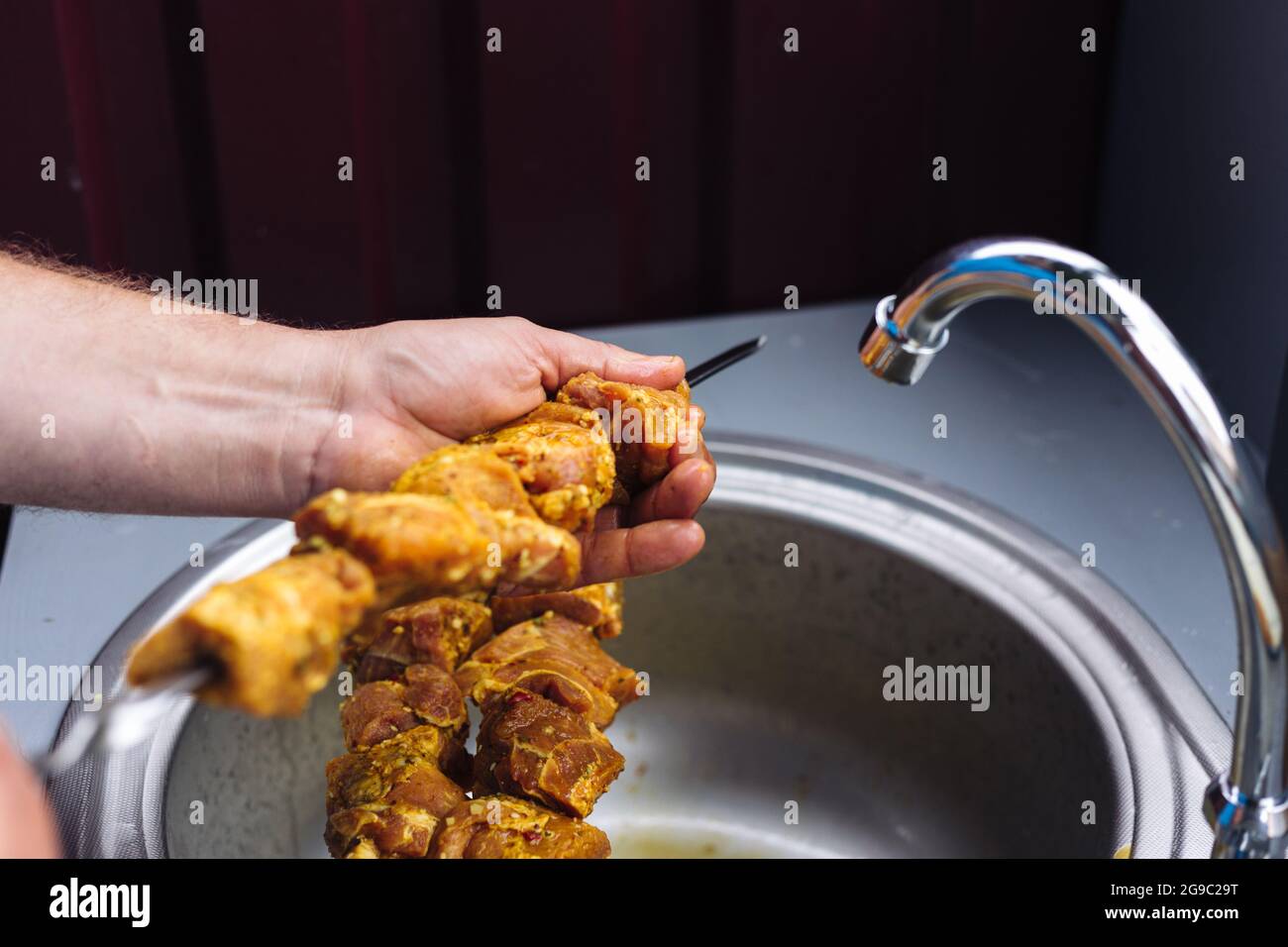 The chef stringing meat on skewers for cooking Stock Photo - Alamy