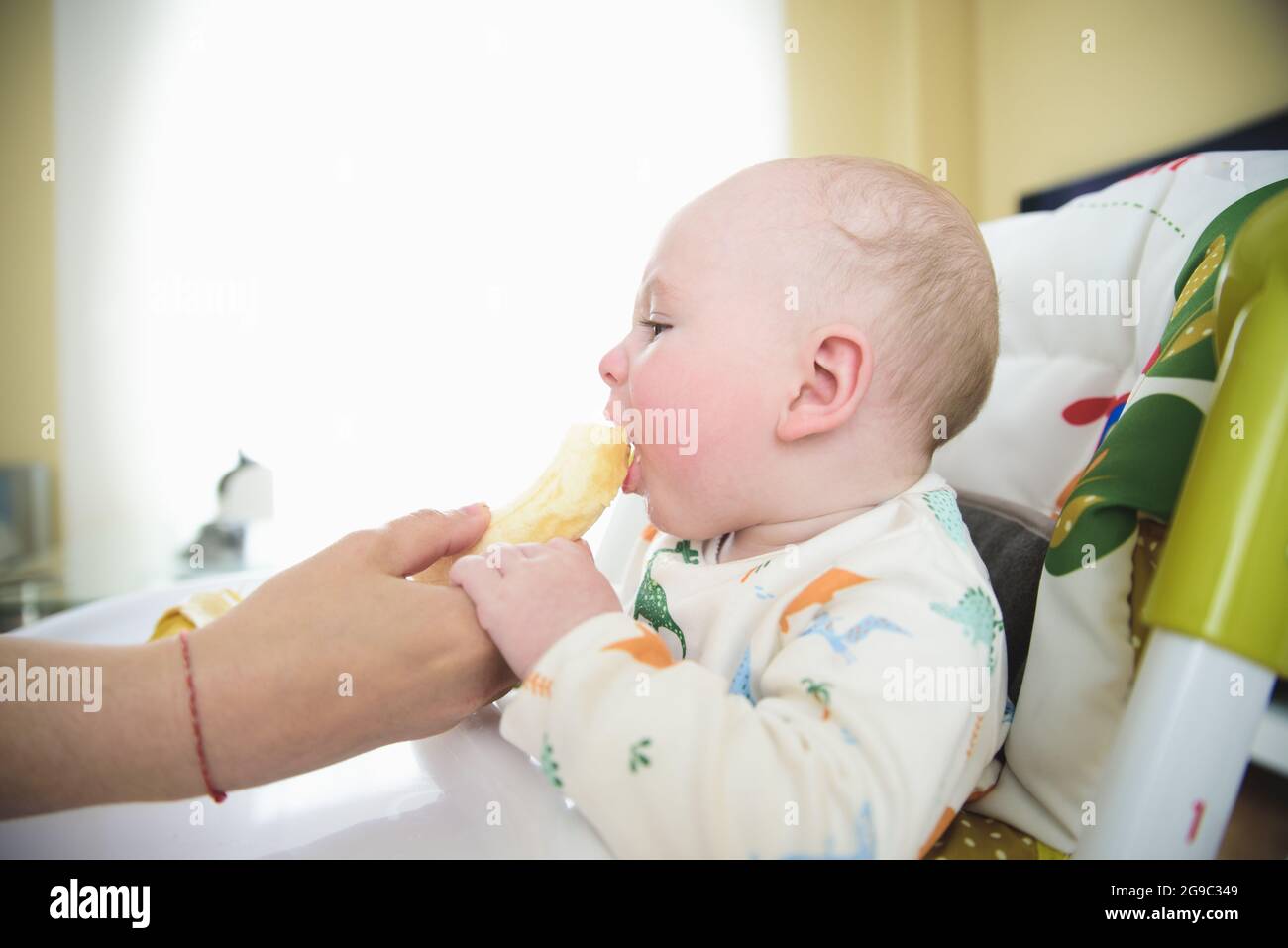 woman giving banana to her baby Stock Photo - Alamy