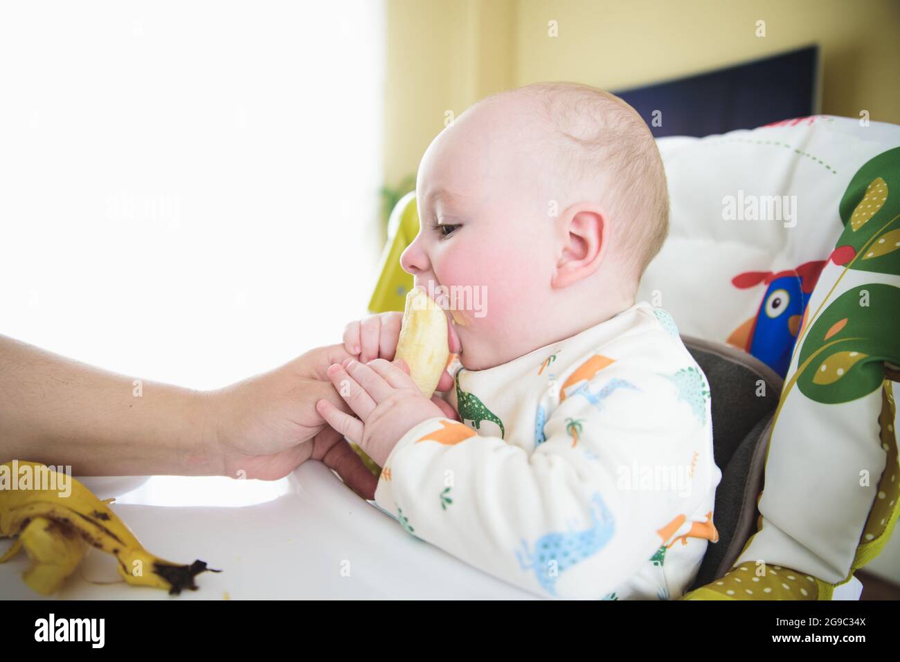 woman giving banana to her baby Stock Photo - Alamy