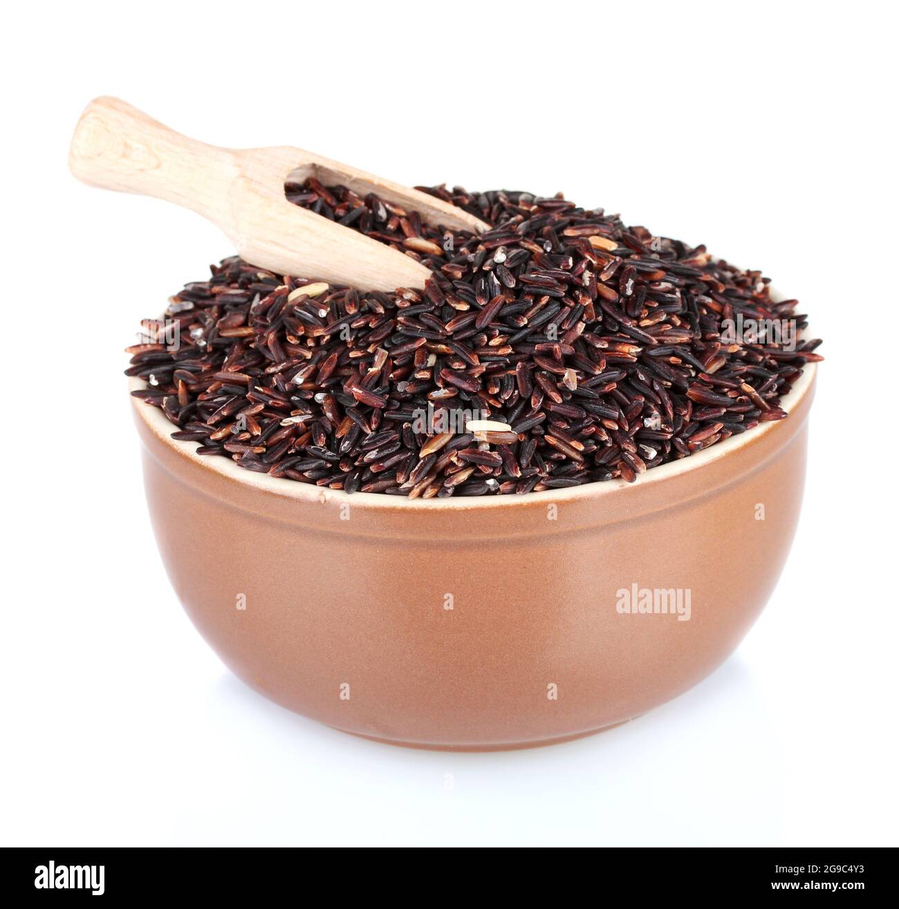 black rice in a brown platewith a wooden scoop , isolated on white ...