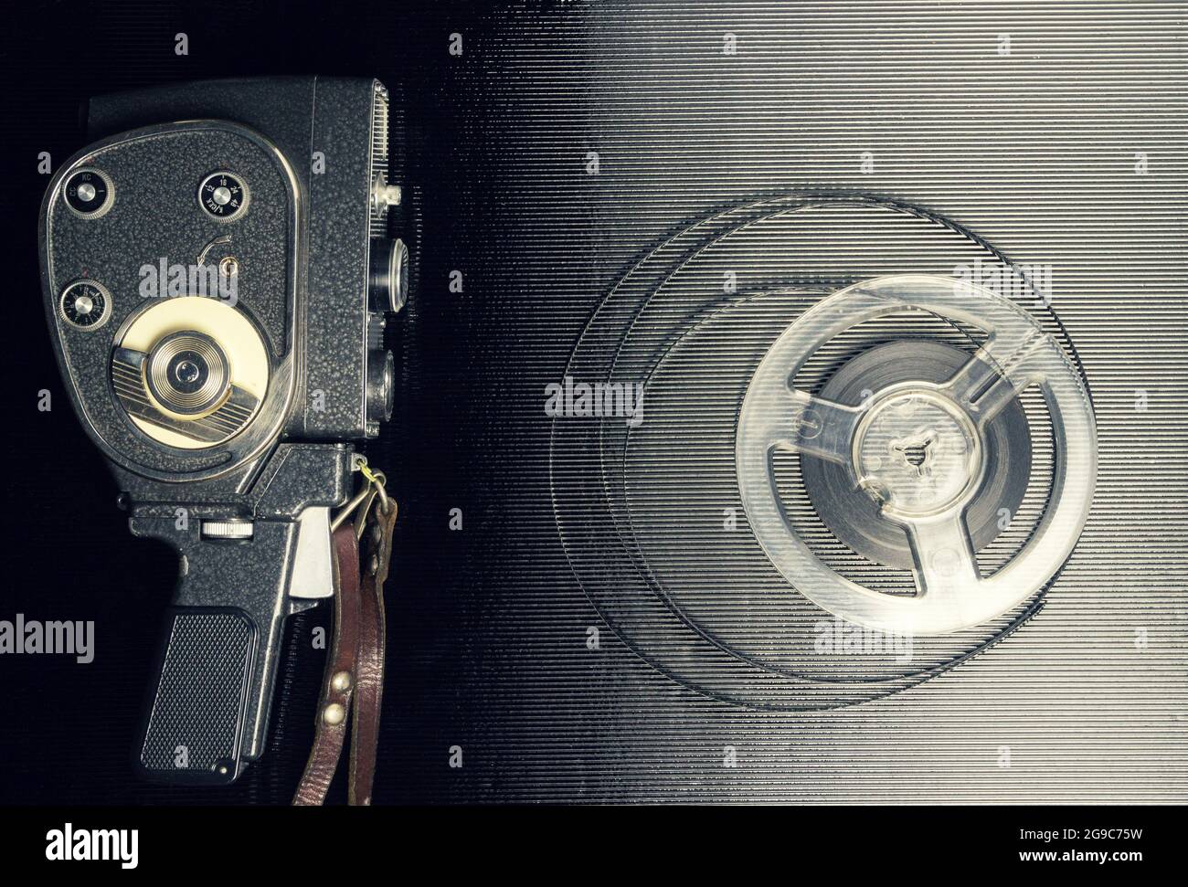 Old amateur movie camera and reel of film stock on black background ...