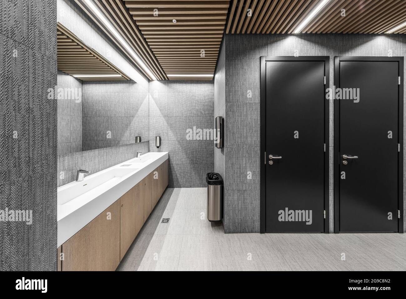 Interior of a modern public restroom with wood and grey clay elements ...